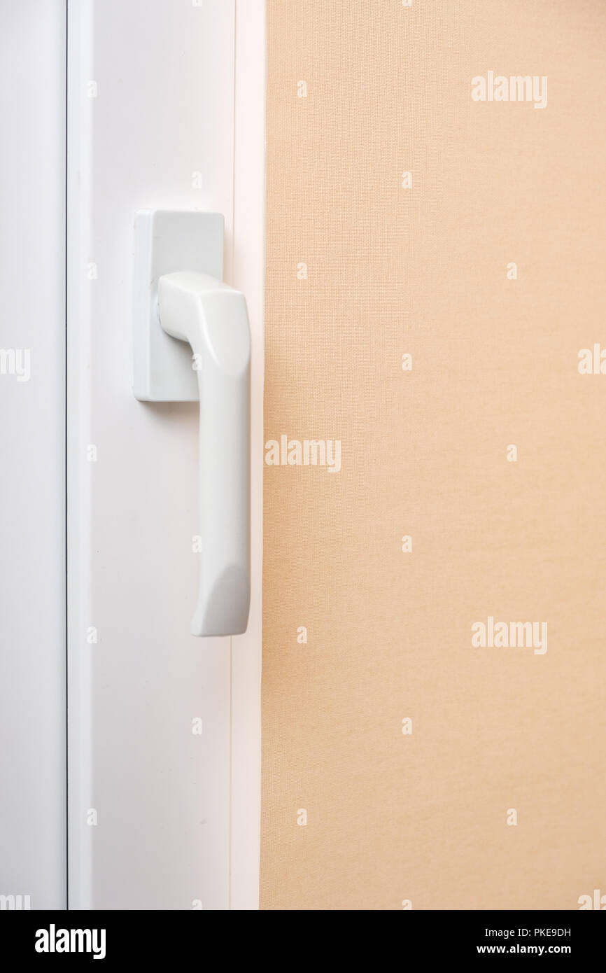 Beige blackout roller blind on the white plastic window. Shutters on ...