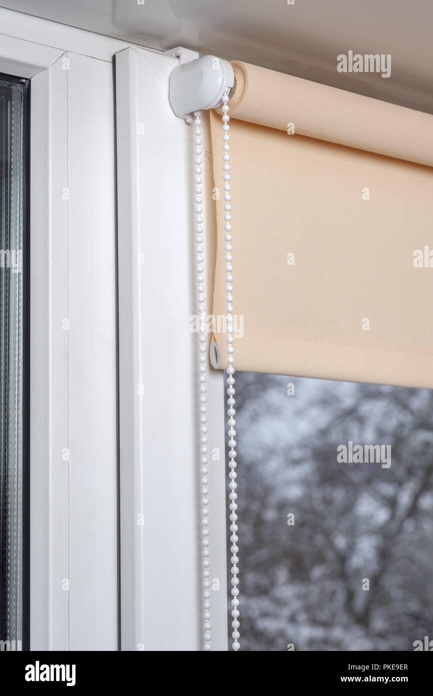 Beige blackout roller blind on the white plastic window. Shutters on ...