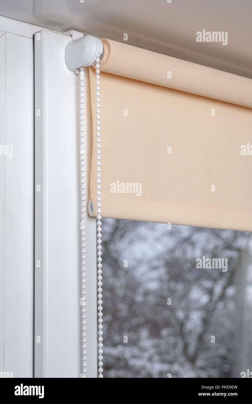 Beige blackout roller blind on the white plastic window. Shutters on ...