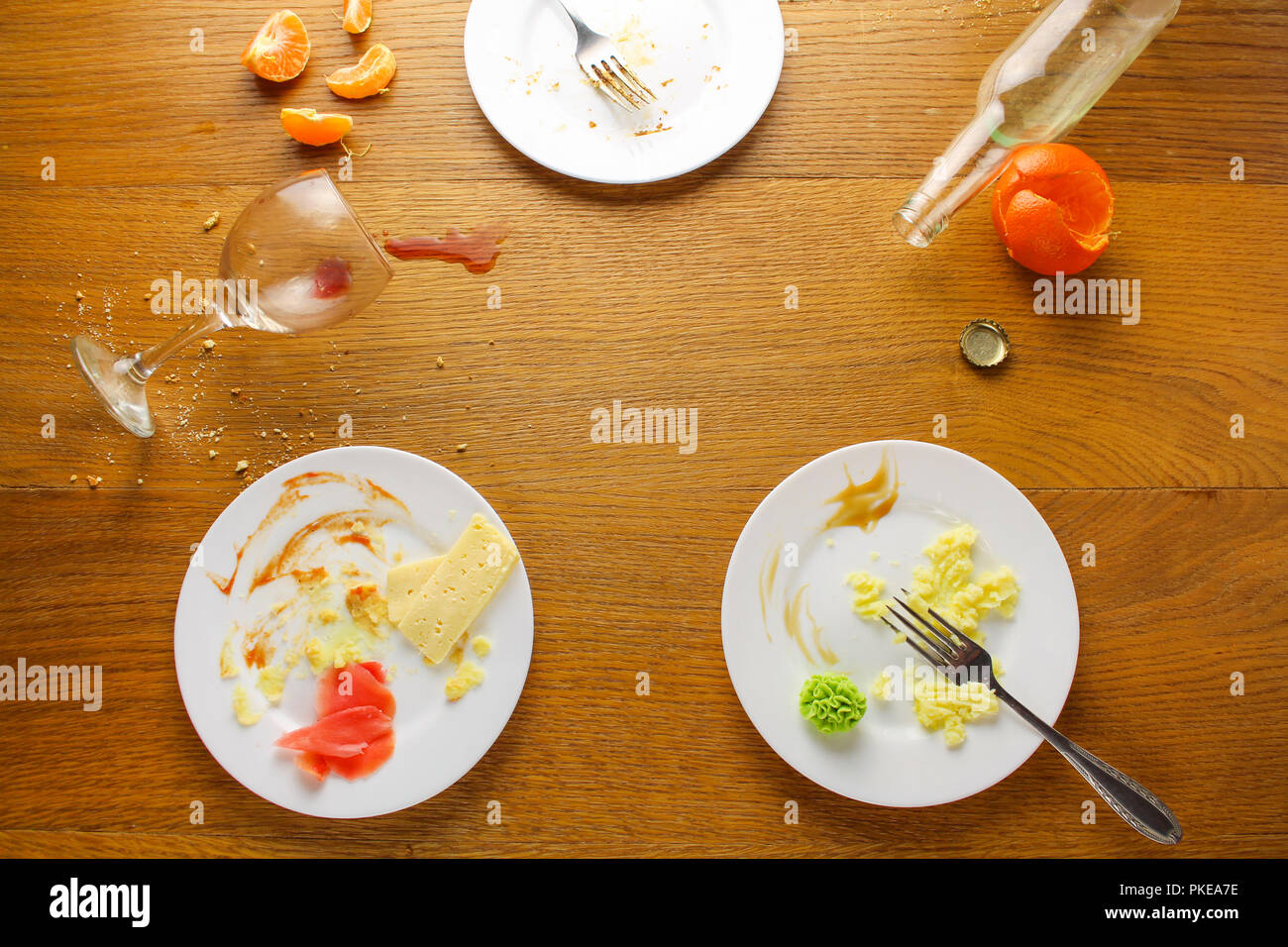 Messy table after party. Leftover food, spilled drinks, dirty dishes ...