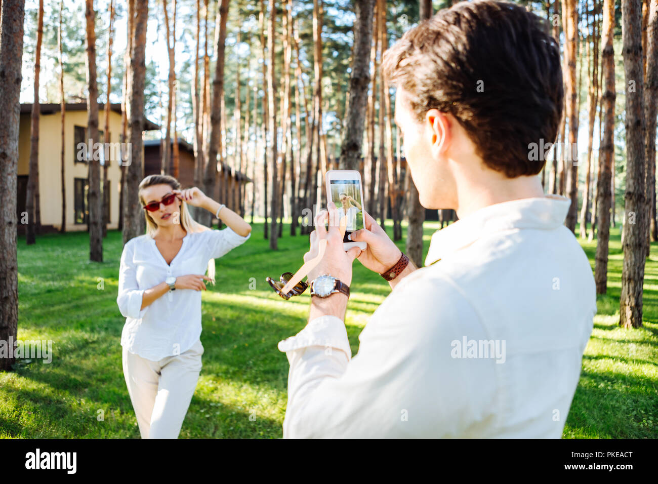 Nice smart man taking photo of his girlfriend Stock Photo - Alamy