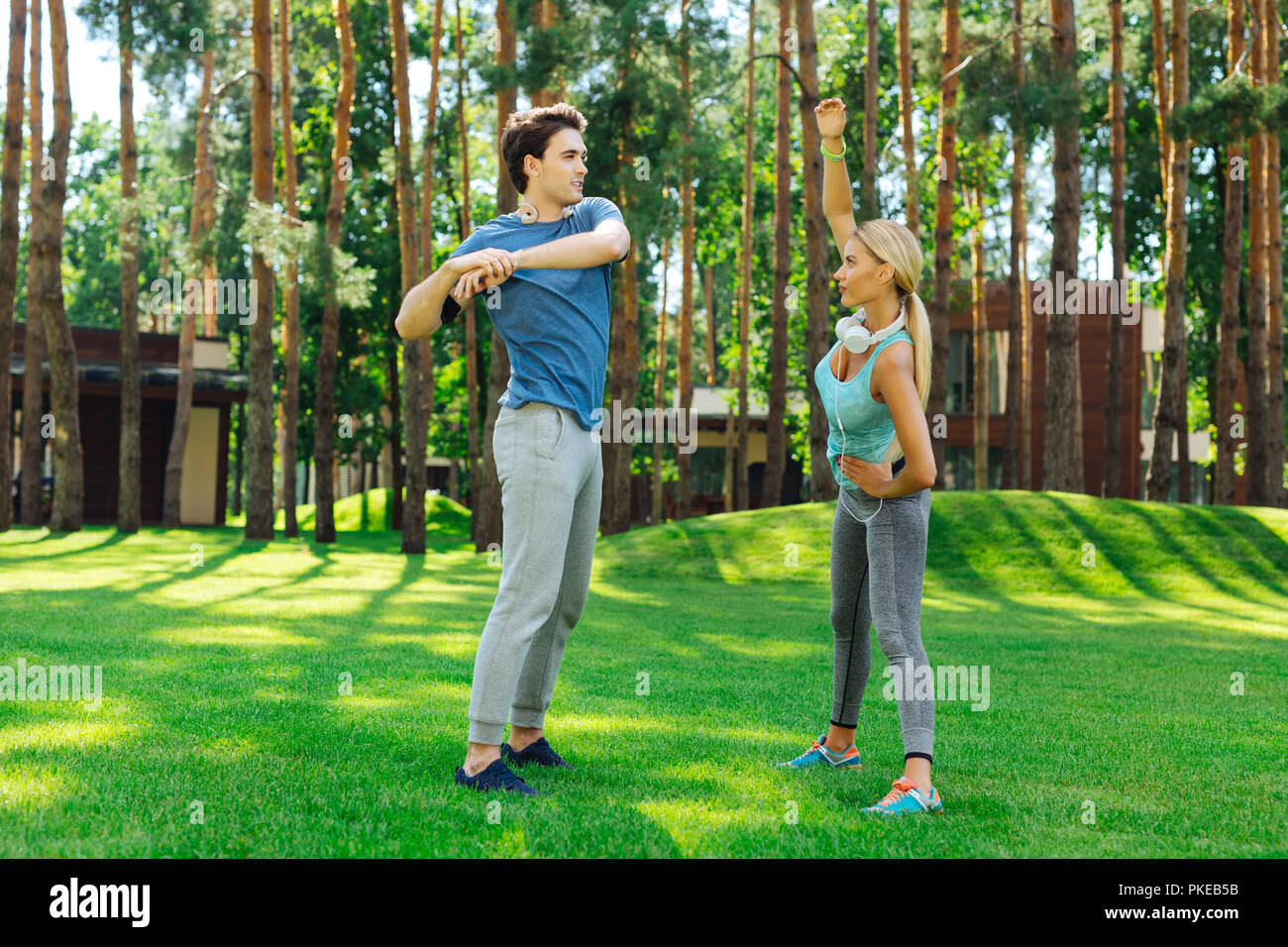 Nice young people doing sports exercises together Stock Photo - Alamy
