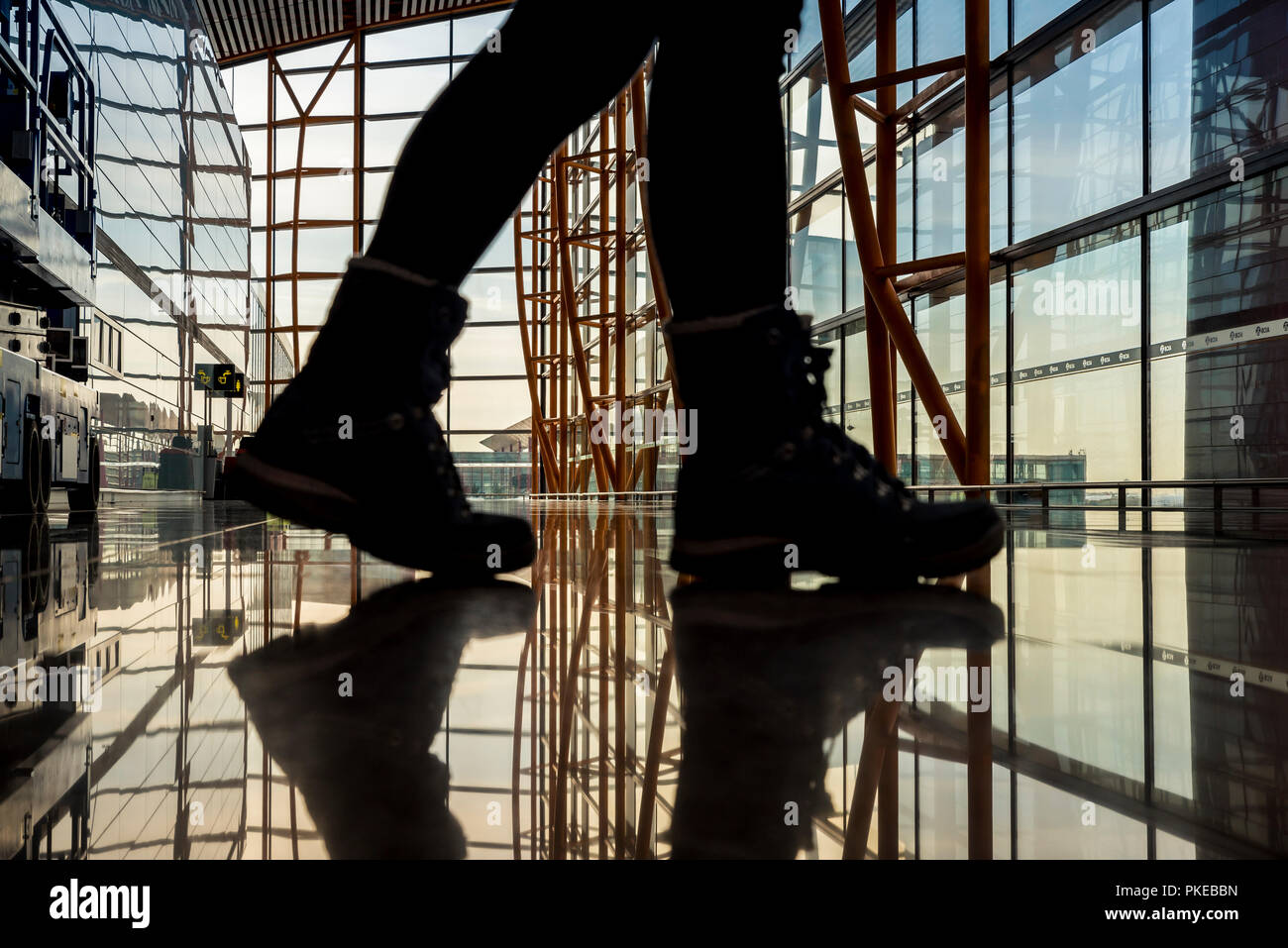 Feet walking and reflected on glossy floor of the terminal building ...