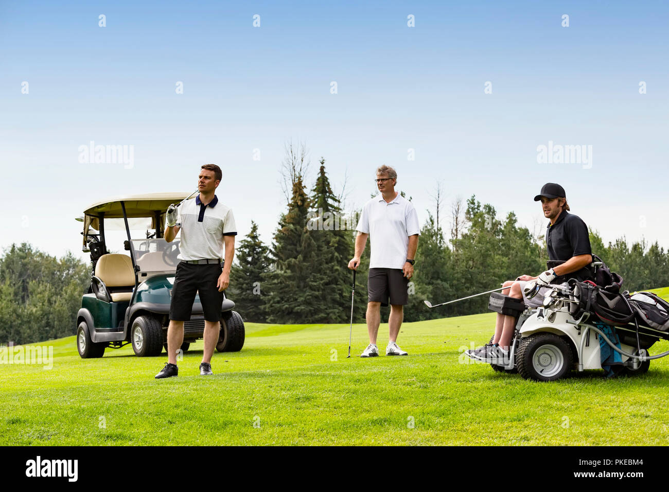 A group of golfers, one of which is handicapped with a mobility ...