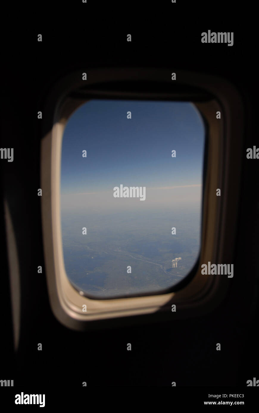 Porthole view out of a ryanair plane window in flight shows summer sky ...