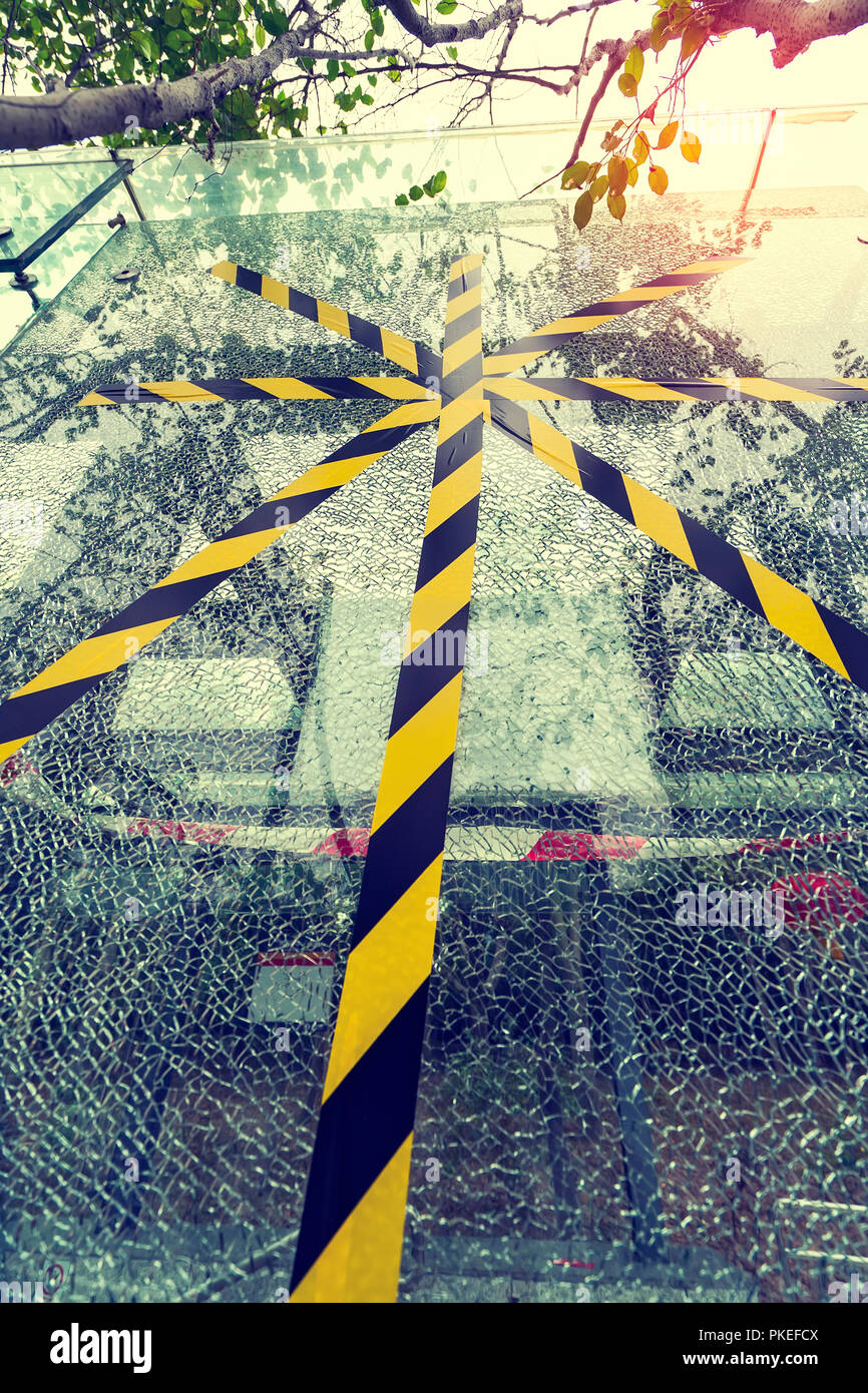 Yellow tape across broken glass window Stock Photo - Alamy