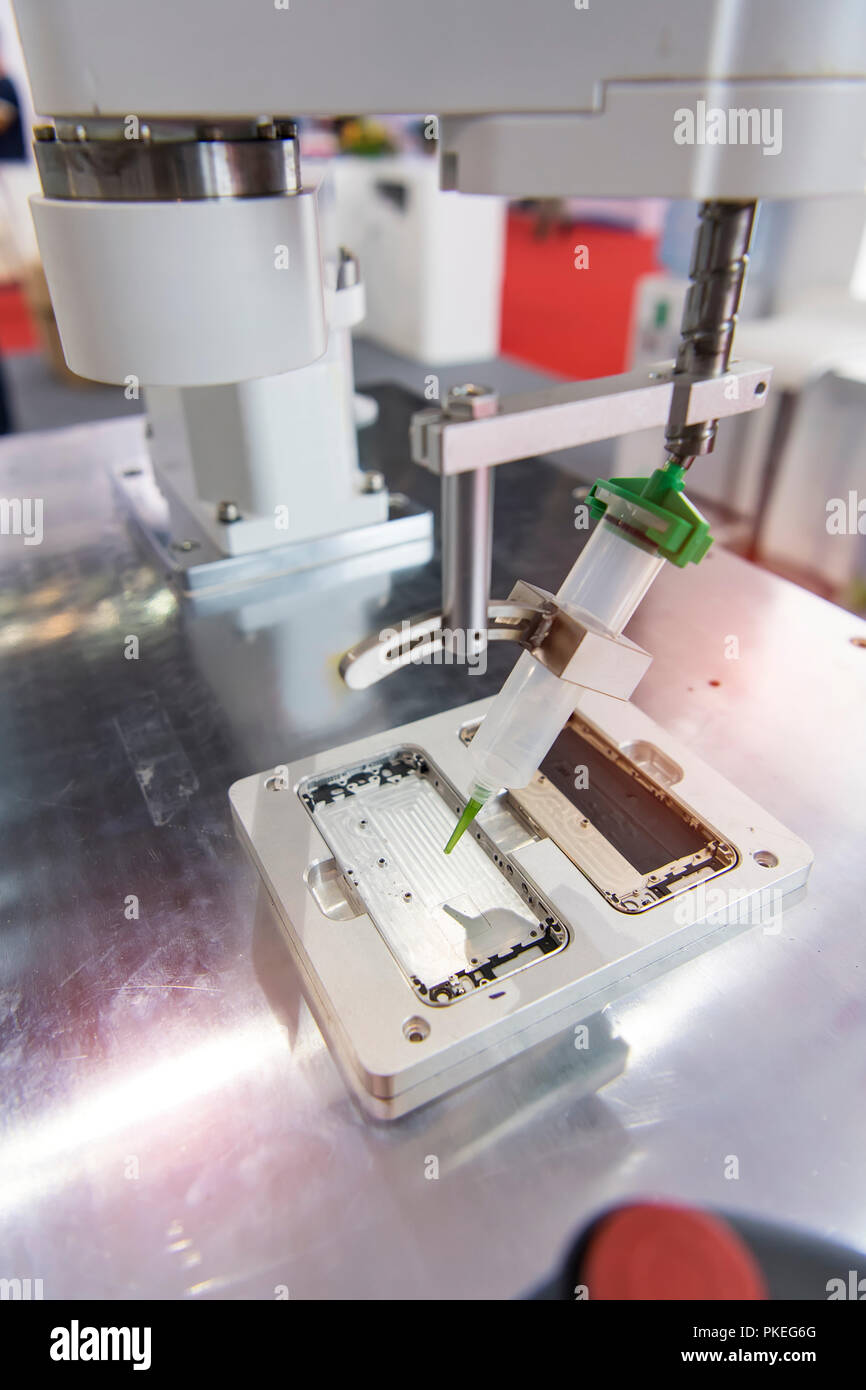 Robot holding glue syringe Injection in mobile phone factory Stock ...