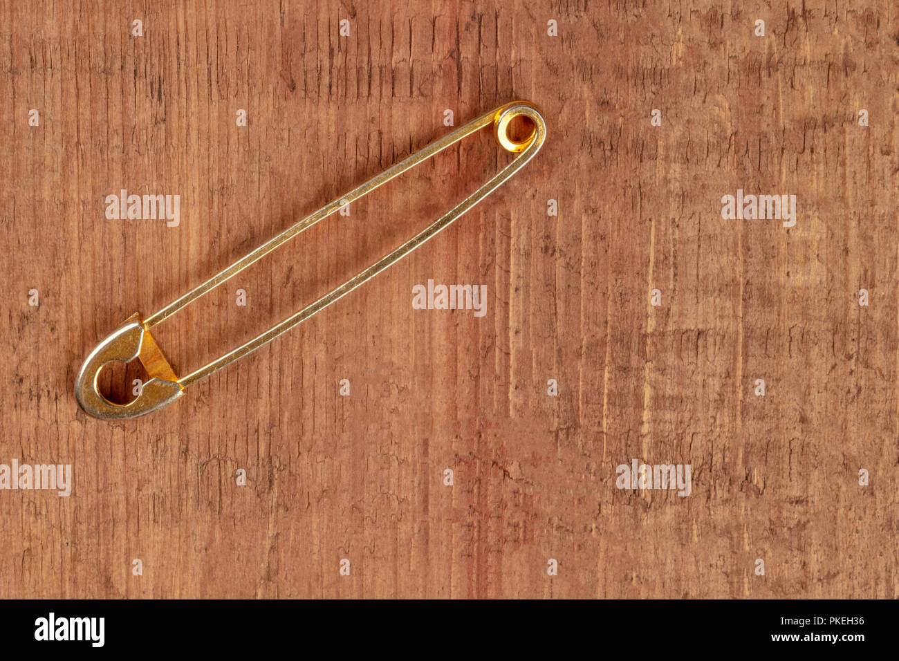 An overhead photo of a vintage safety pin, shot from above on a dark ...