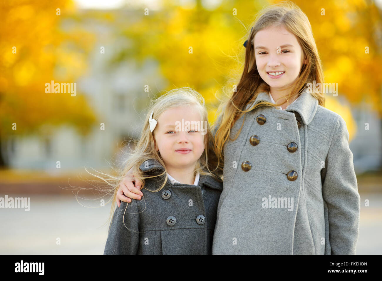 Two cute little girls having fun on beautiful autumn day. Happy ...
