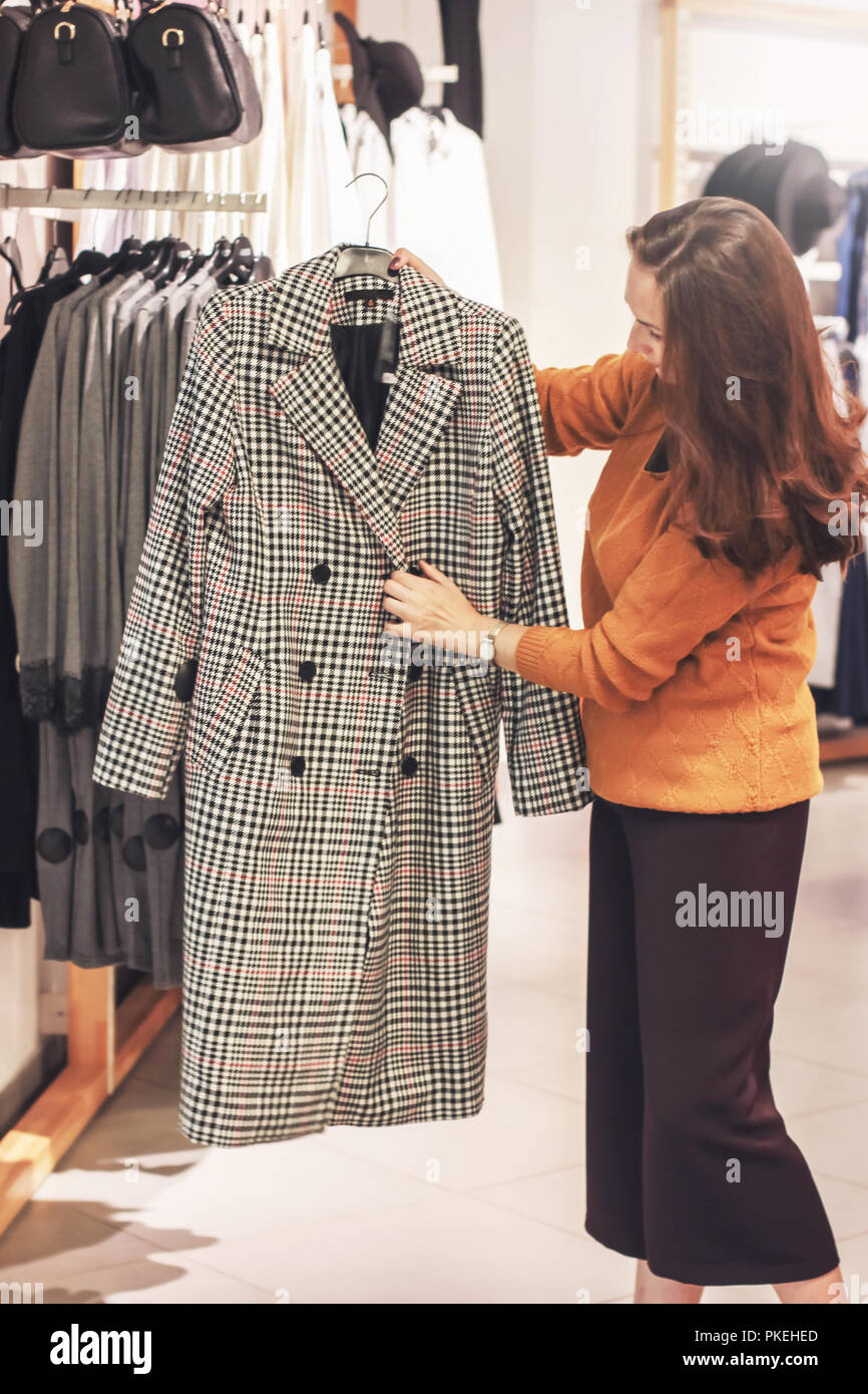 Woman trying on coat in cage in the store Stock Photo - Alamy