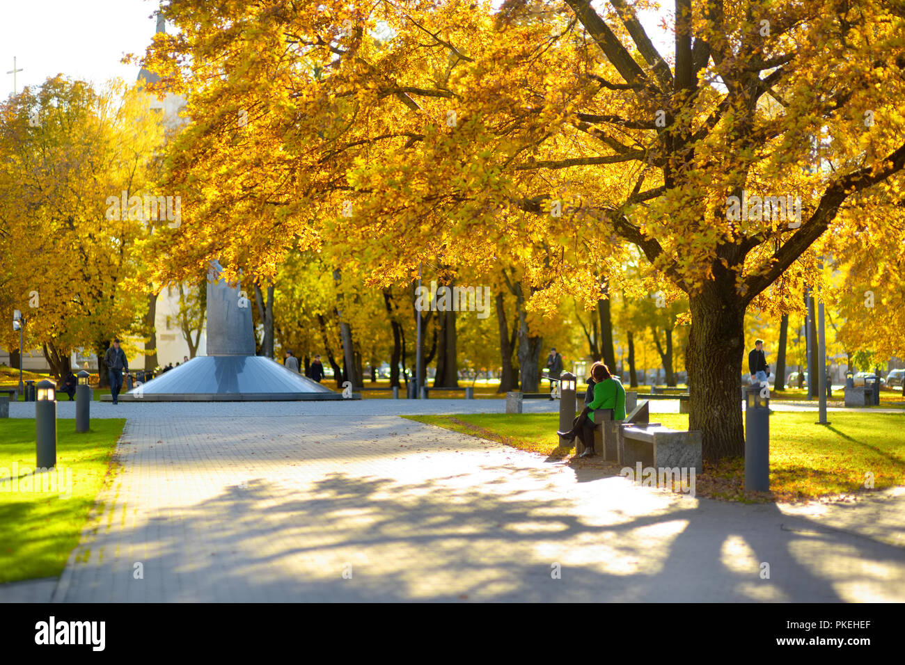 Colorful city park scene in the fall with orange and yellow foliage ...
