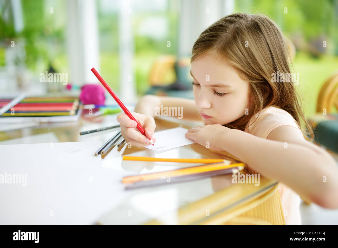 Cute little girl drawing with colorful pencils at a daycare. Creative ...