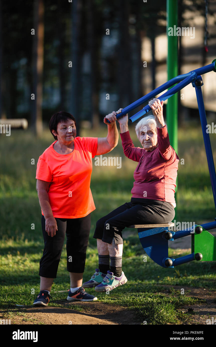 Elderly woman is doing exercises on sport playground in the Park Stock ...