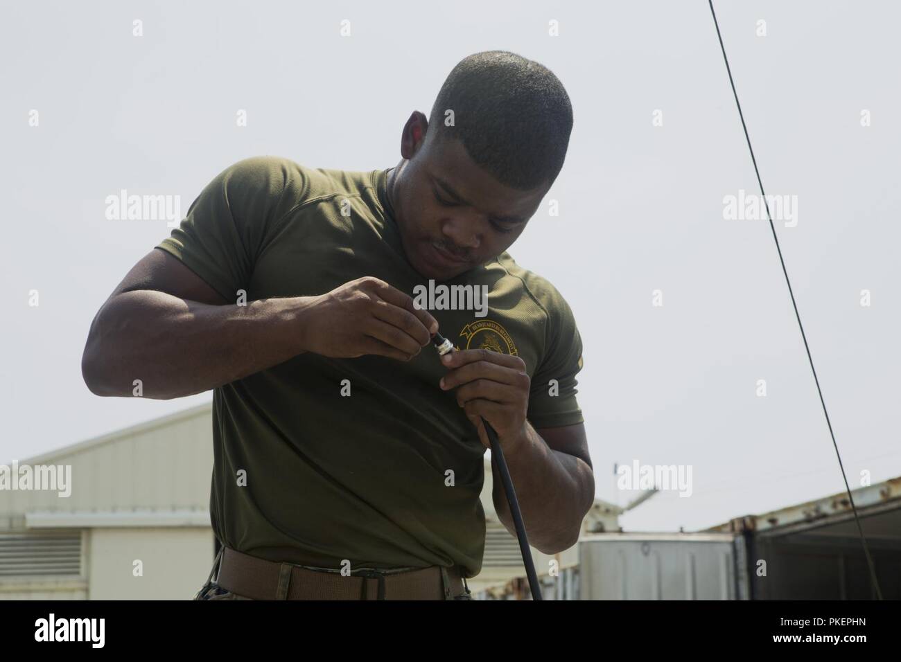 Cpl. Tevin B. Robinson repairs a radio frequency cable at Camp Kinser ...
