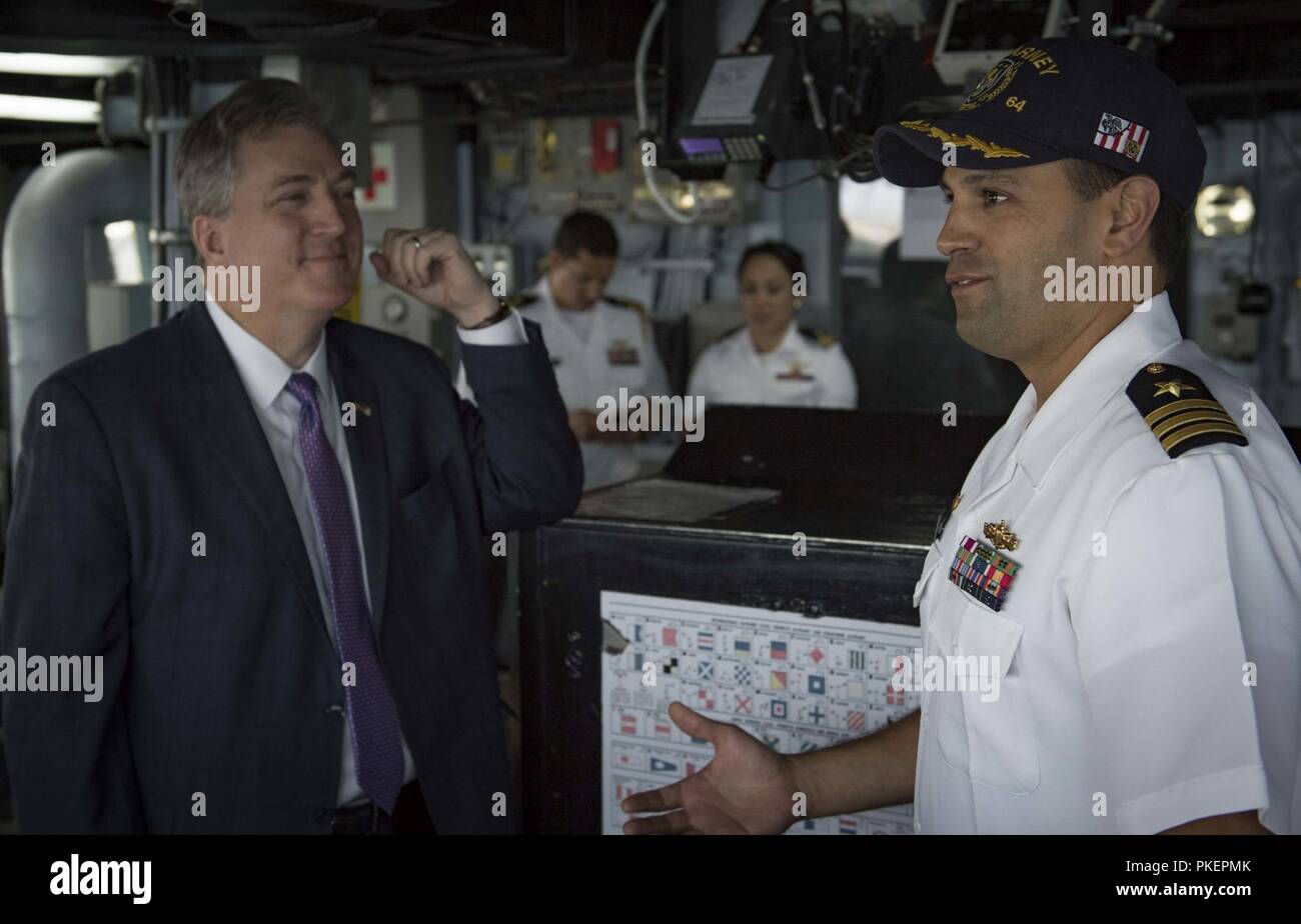 Algeria (July 29, 2018) Cmdr. Tyson Young, right, commanding officer of ...