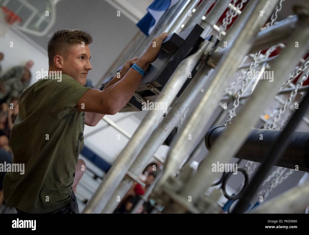An athlete tests his grip on the first obstacle of the Alpha Warrior ...
