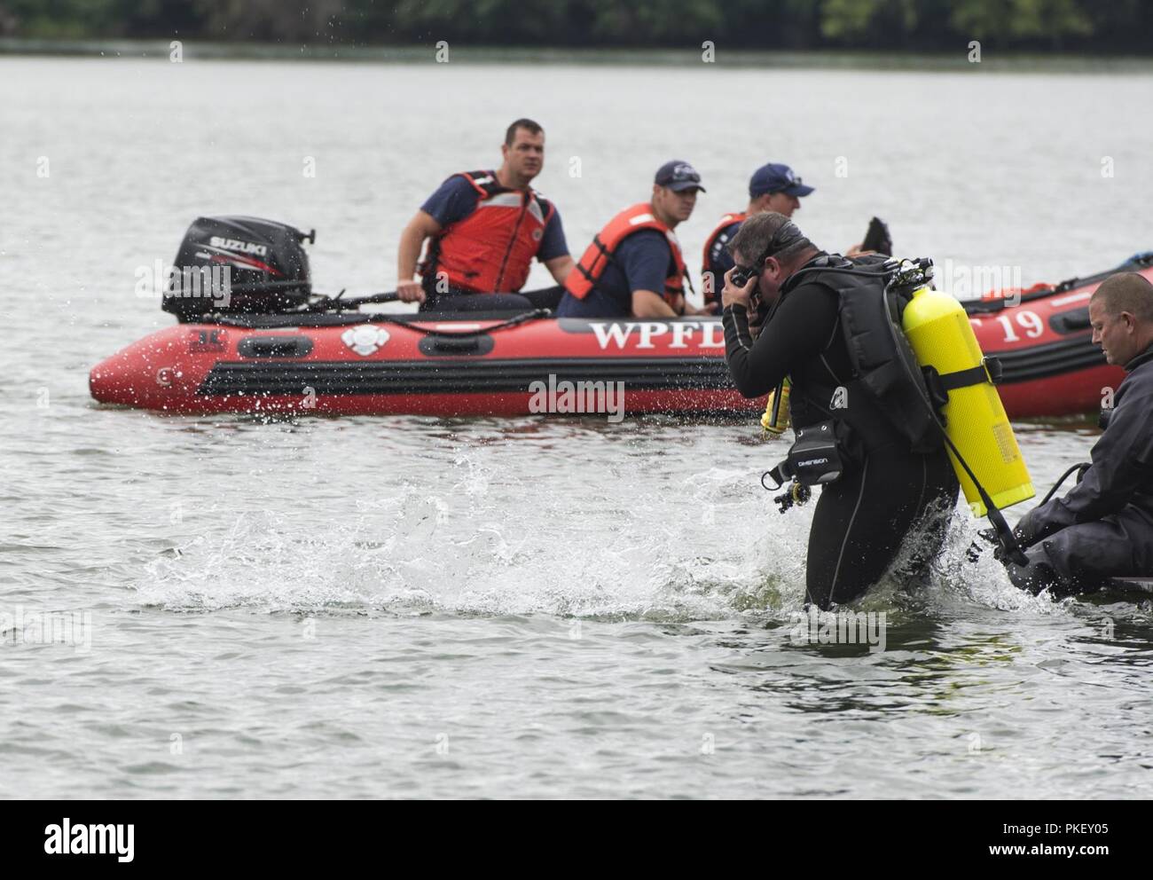 A diver from the 788th Civil Engineer Fire Department, steps into the ...