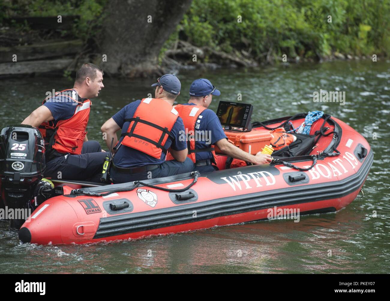A crew from the 788th Civil Engineer Fire Department use a boat and ...