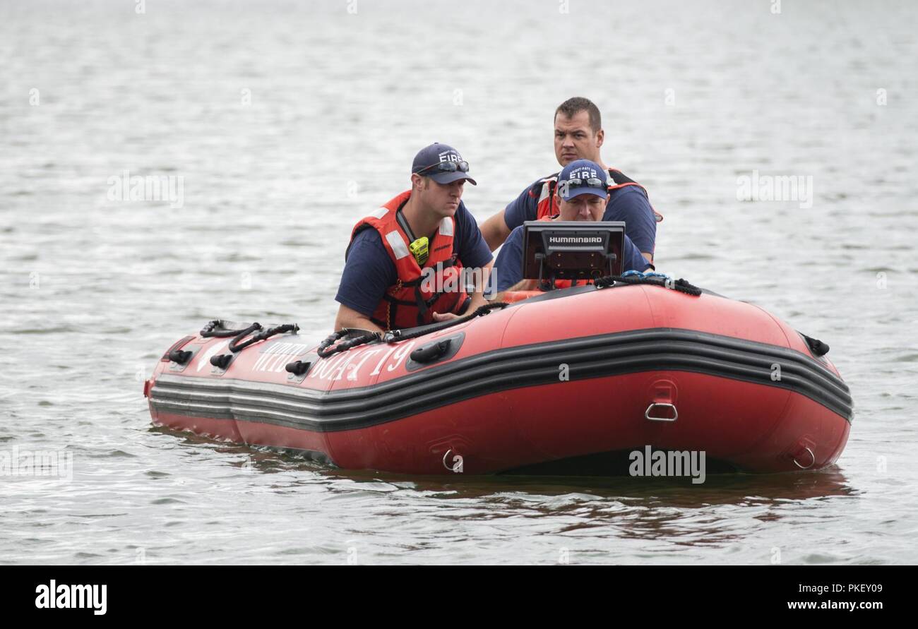 A crew from the 788th Civil Engineer Fire Department use a boat and ...
