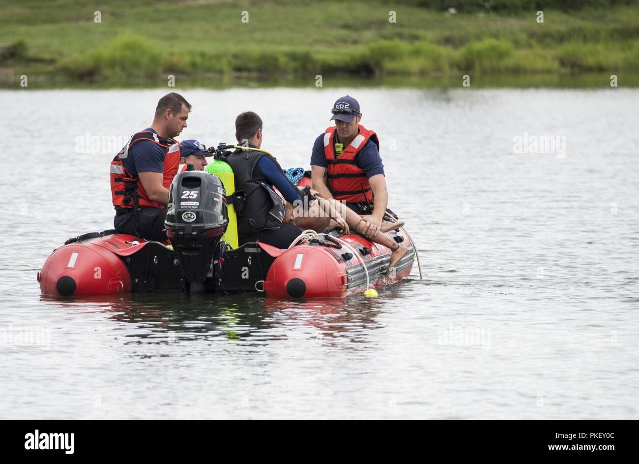 A crew pulls a dummy, simulating a drowning subject from Bass Lake as ...