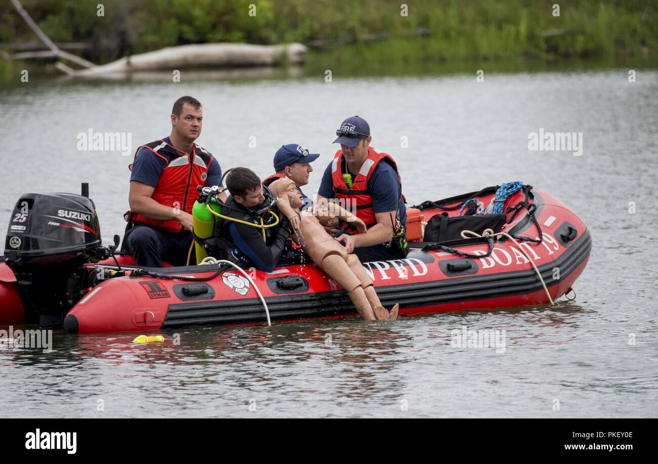 A crew pulls a dummy, simulating a drowning subject from Bass Lake as ...