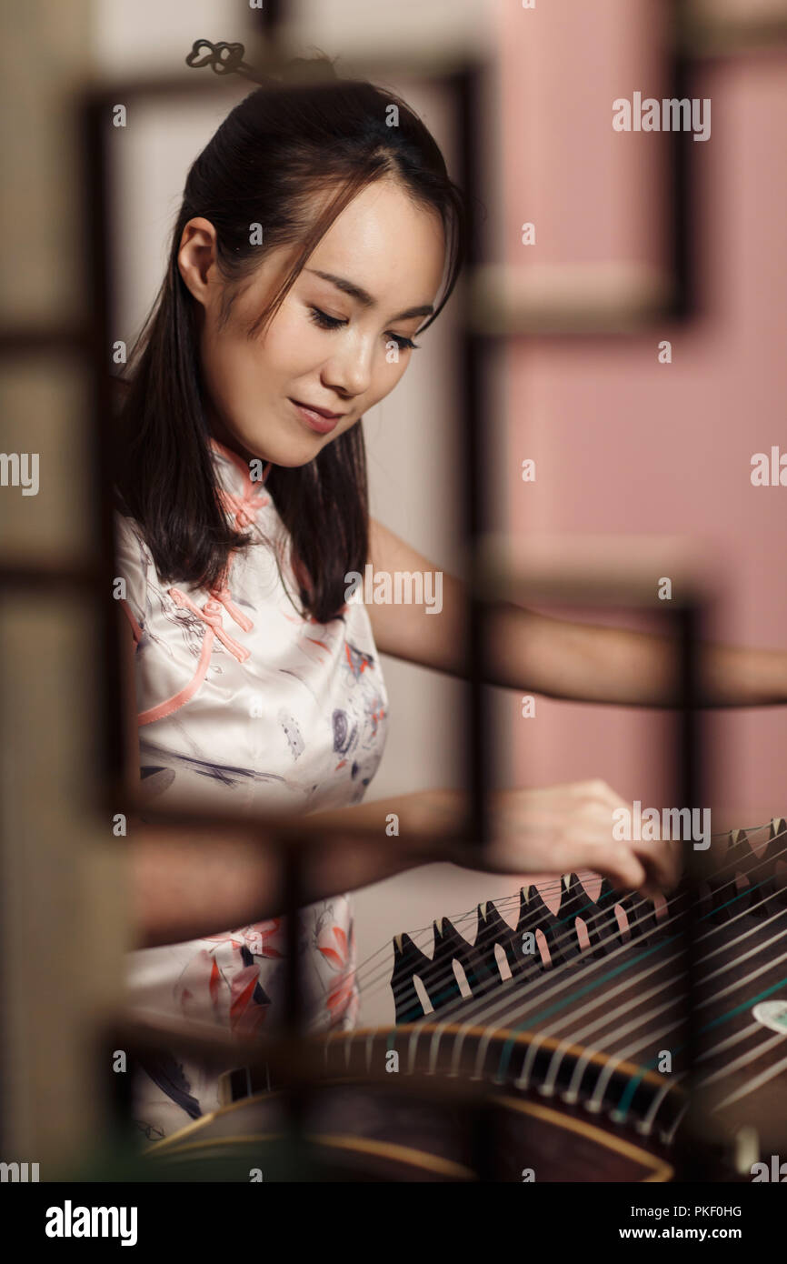 The young woman playing guzheng Stock Photo - Alamy