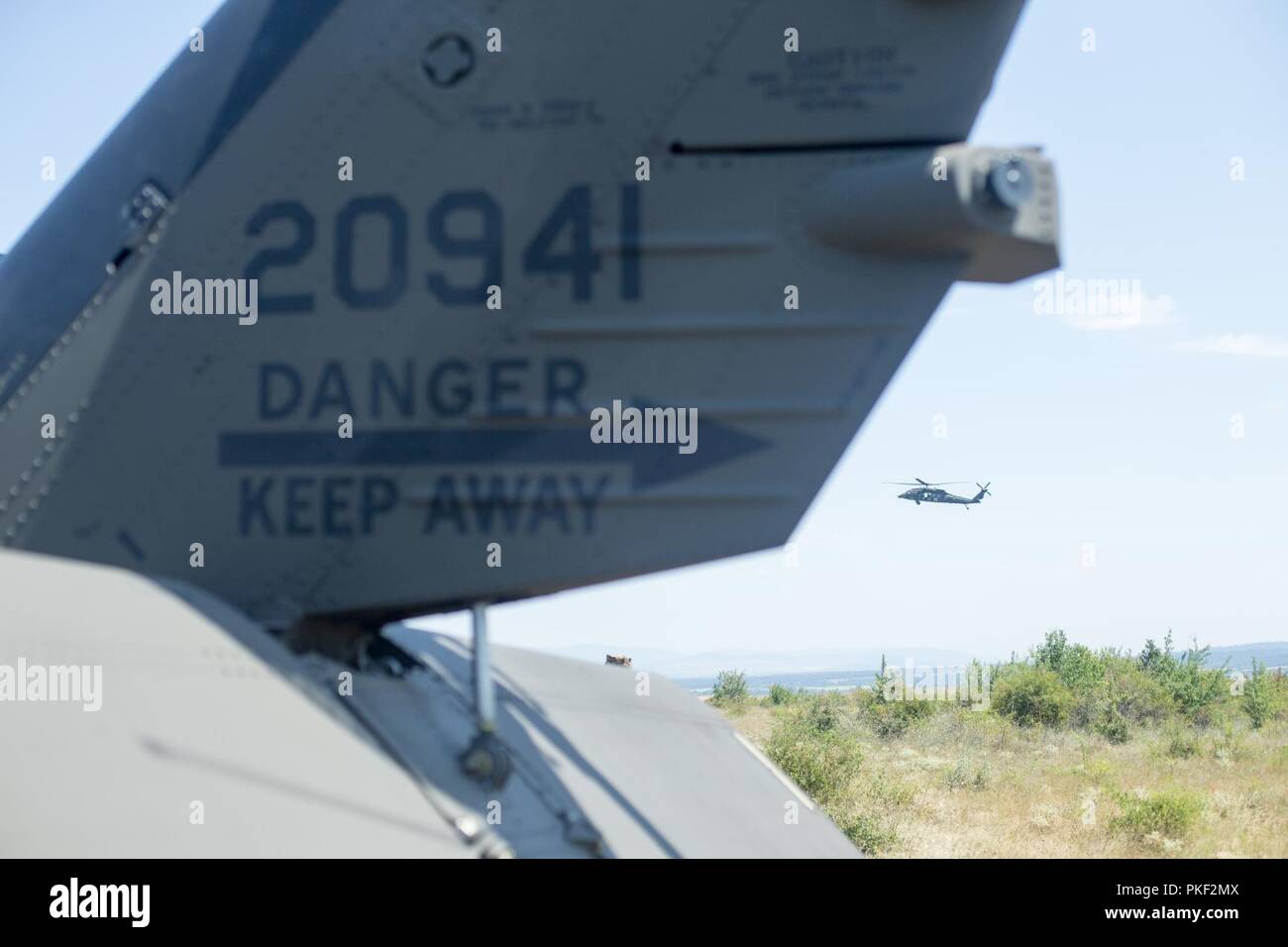 A U.S. Army HH-60M MEDEVAC Black Hawk helicopter passes in the distance ...