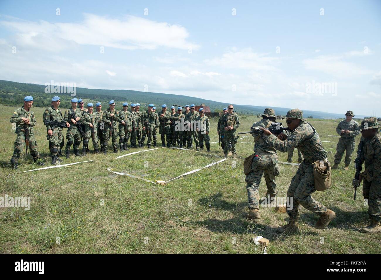 Members of the Albanian Armed Forces watch as a Marine with Black Sea ...