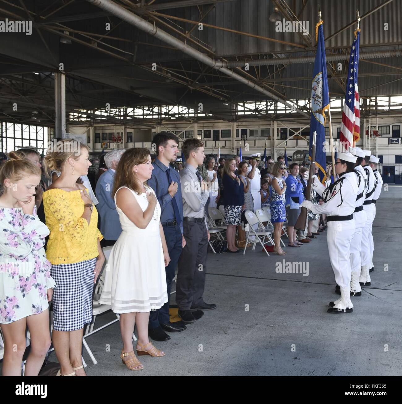 Guests stand during the National Anthem during the official change of ...