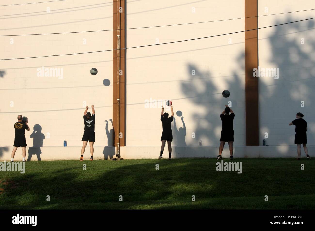 Soldiers conduct a wall ball exercise during circuit training behind ...