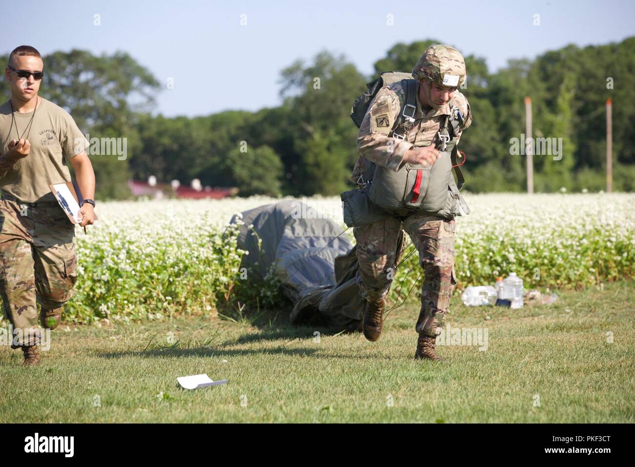 A U.S. Army Paratrooper runs toward the X with his MC-6 parachute on ...