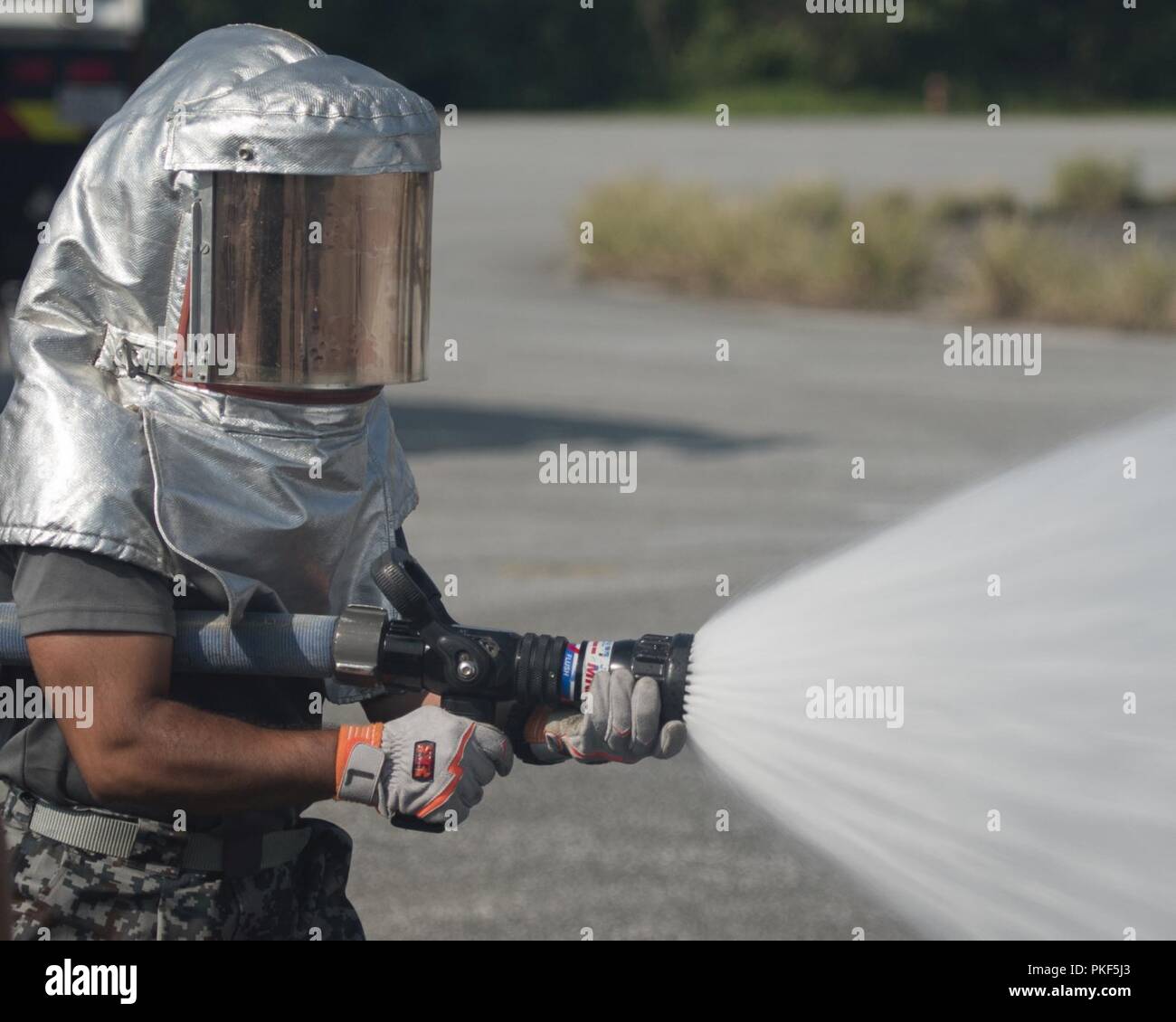 A member from the Naha Air Base fire department test the force of water ...