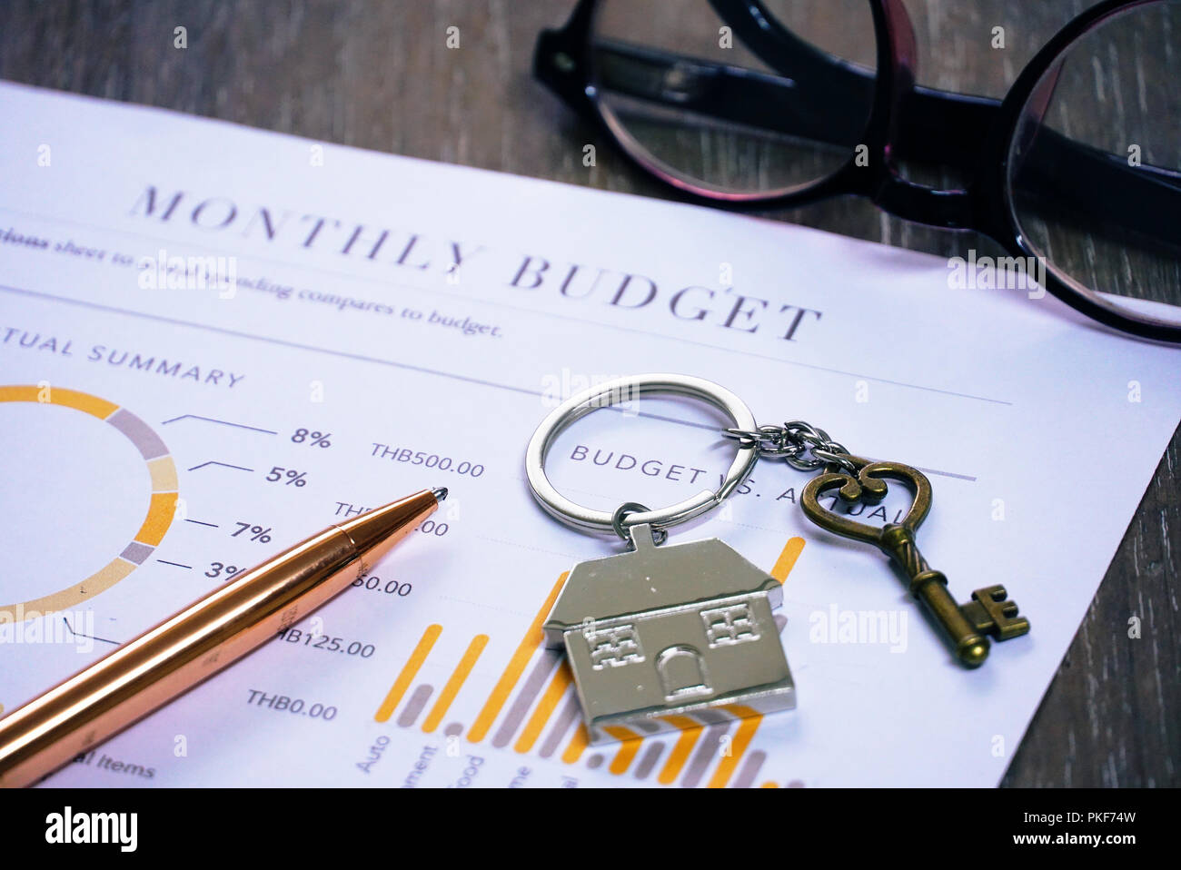 Key with house key chain and glasses lay on budget document,finance ...