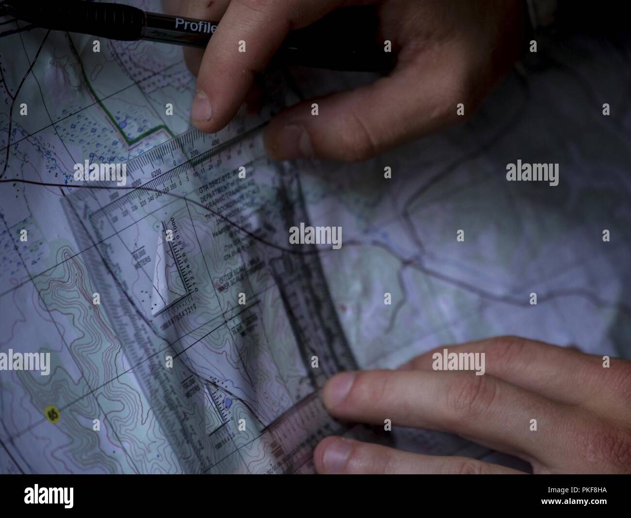 A U.S. Army Reserve military police officer plots grid points on a map ...