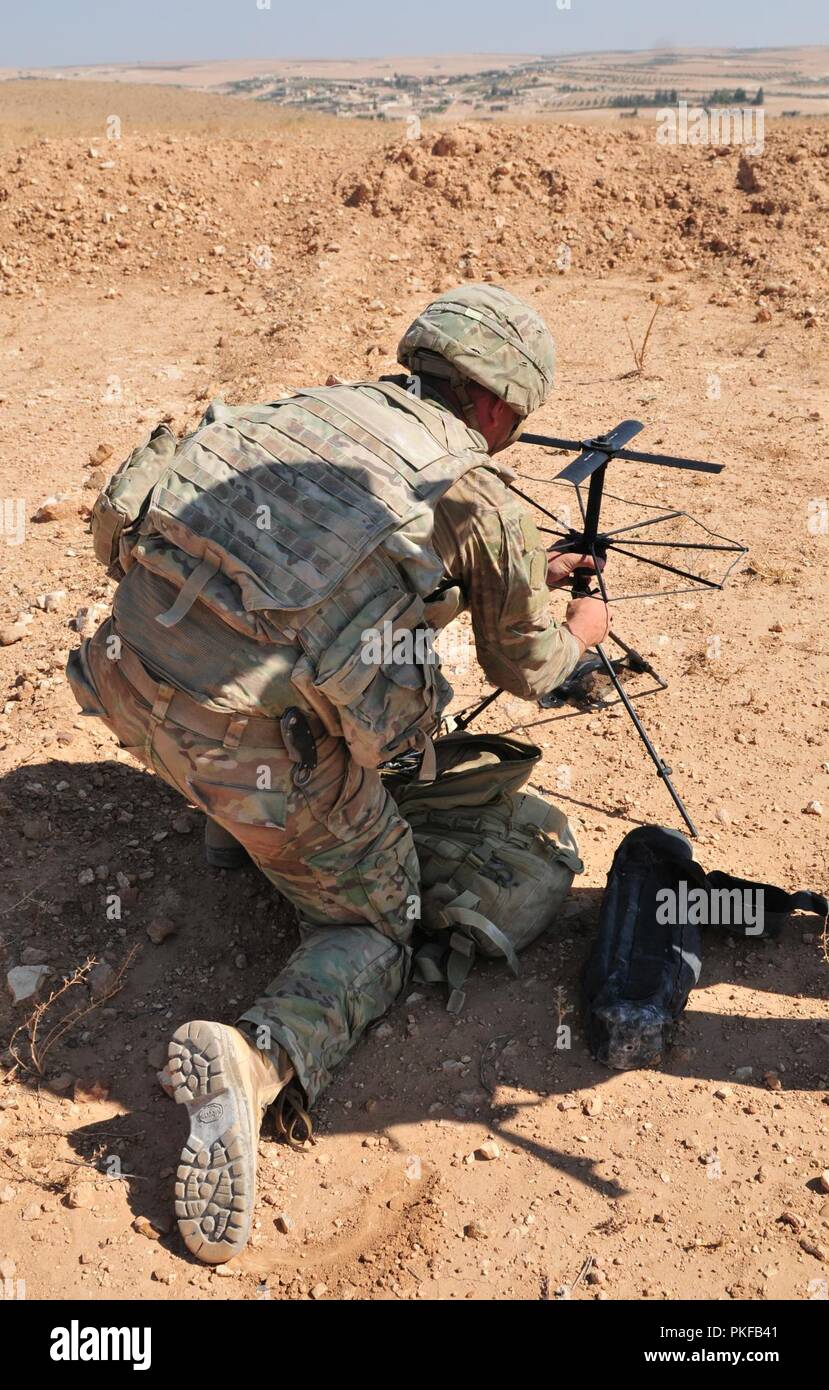 A U.S. Soldier sets up an antenna during a patrol outside Manbij, Syria ...