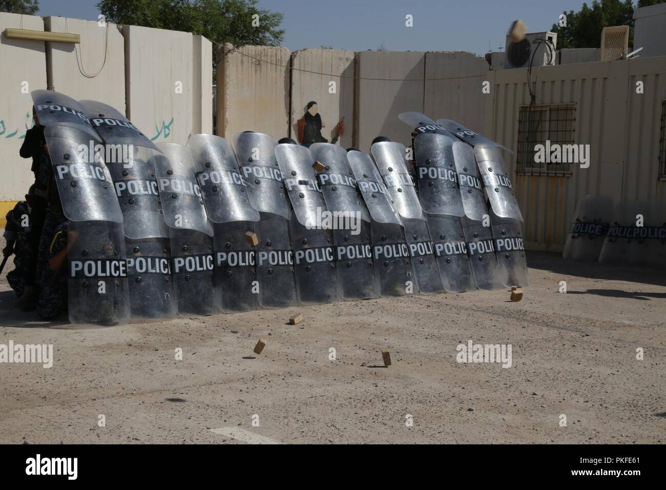 Iraqi Federal Police members gather into a formation using riot shields ...