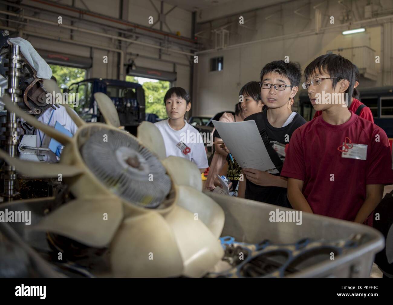 Students from the Misawa City English Camp view pieces of a car engine ...