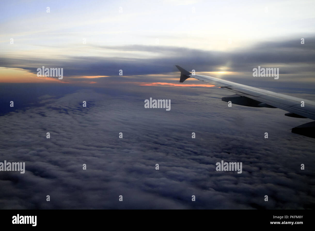 High Altitude Sunset over the Clouds from a Plane Window Stock Photo ...