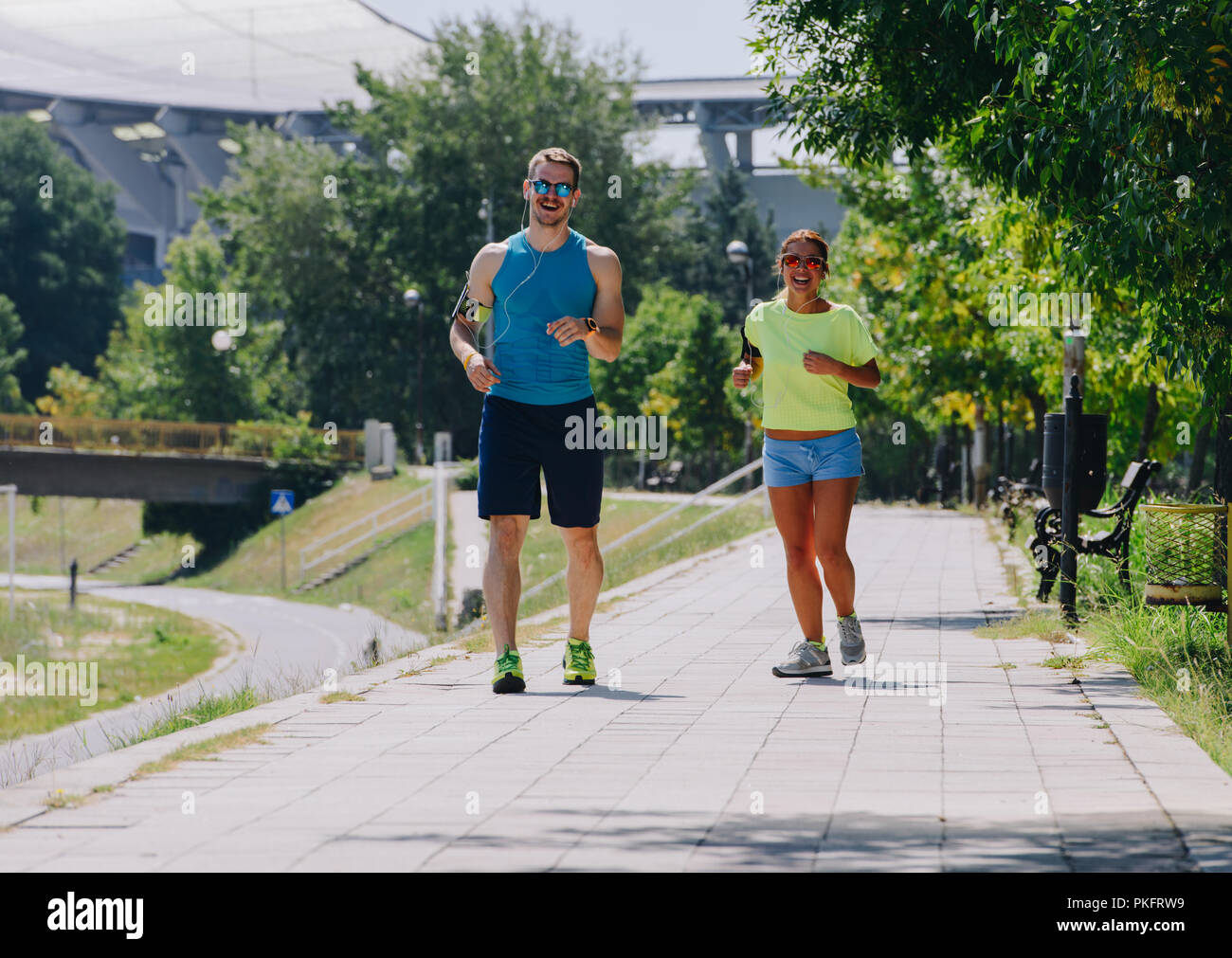 Two athletic people running through the riverside Stock Photo - Alamy