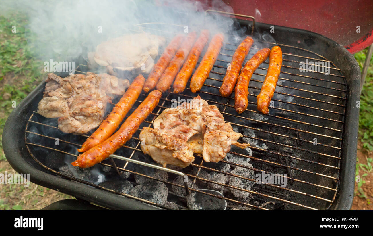 Variety of meat on an outdoor, sunlit, smoking barbecue grill Stock ...