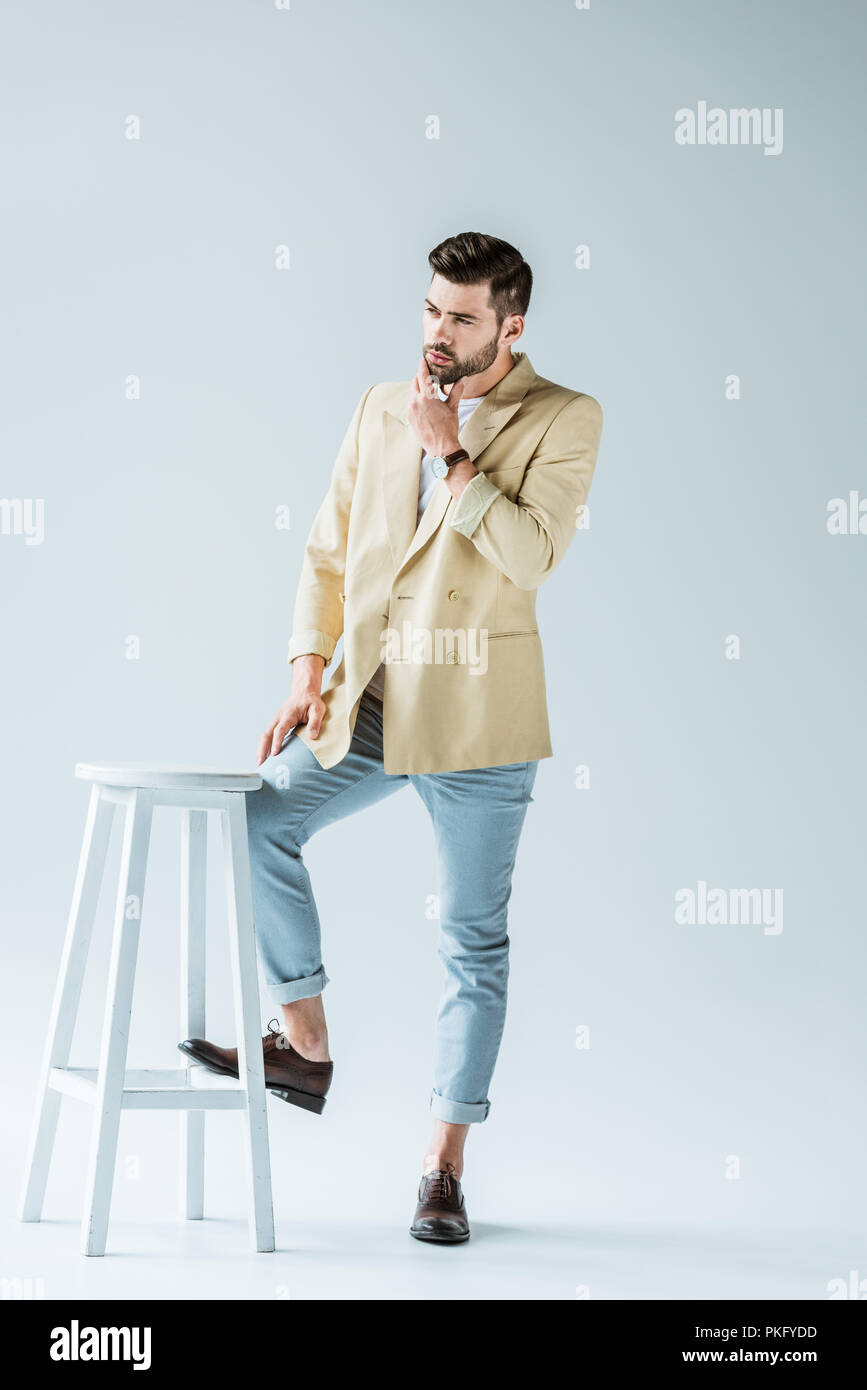 Handsome bearded man leaning on stool on white background Stock Photo ...
