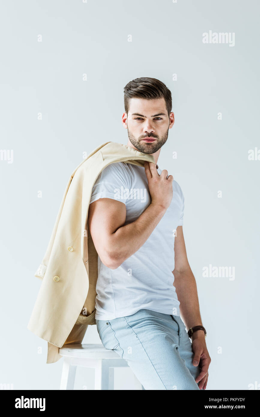 Fashionable confident man holding his jacket isolated on white ...