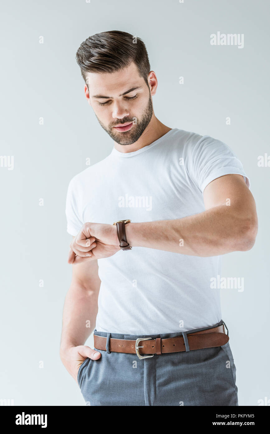 Fashionable confident man checking his watch isolated on white ...