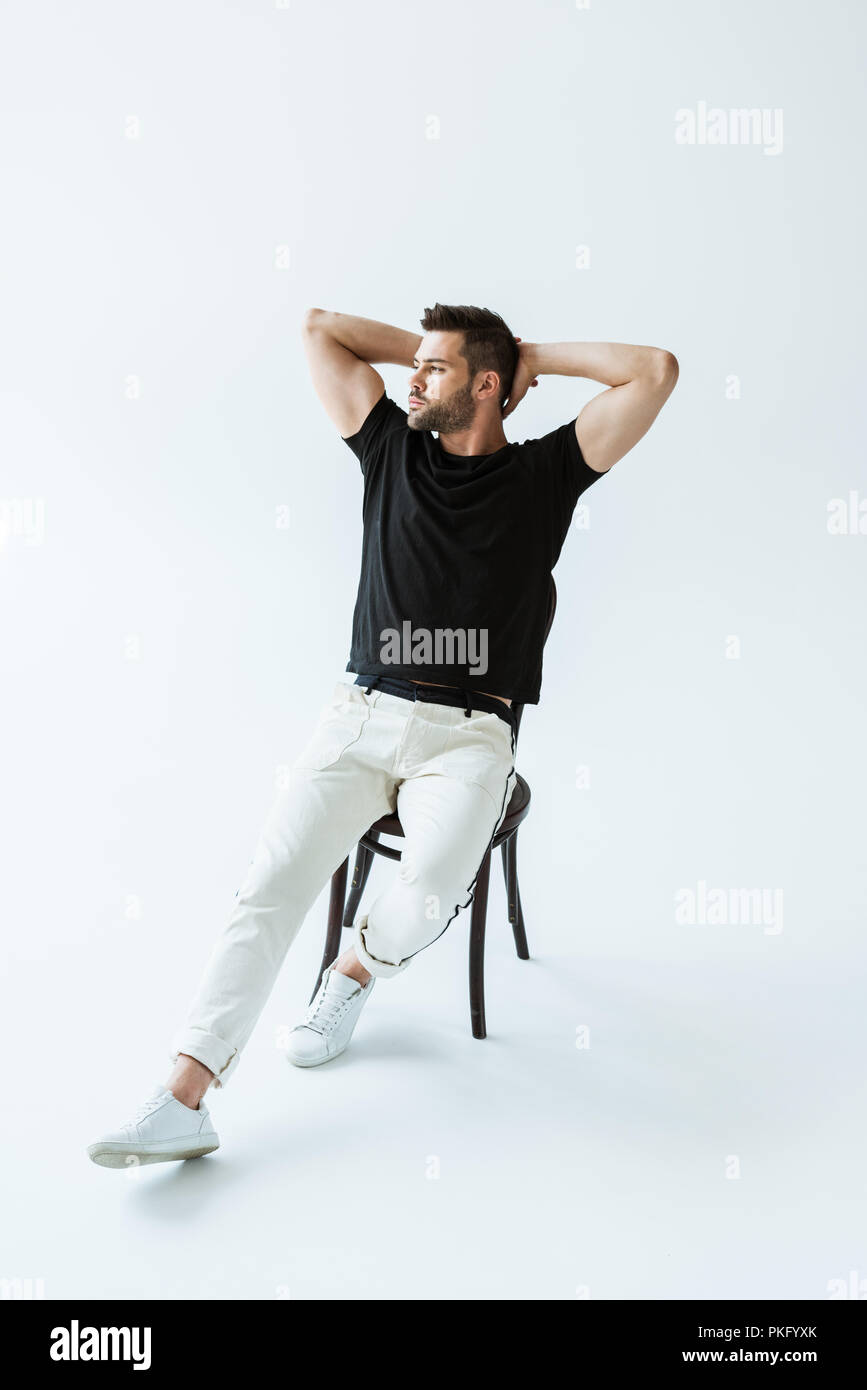 Fashionable confident man resting on chair on white background Stock ...