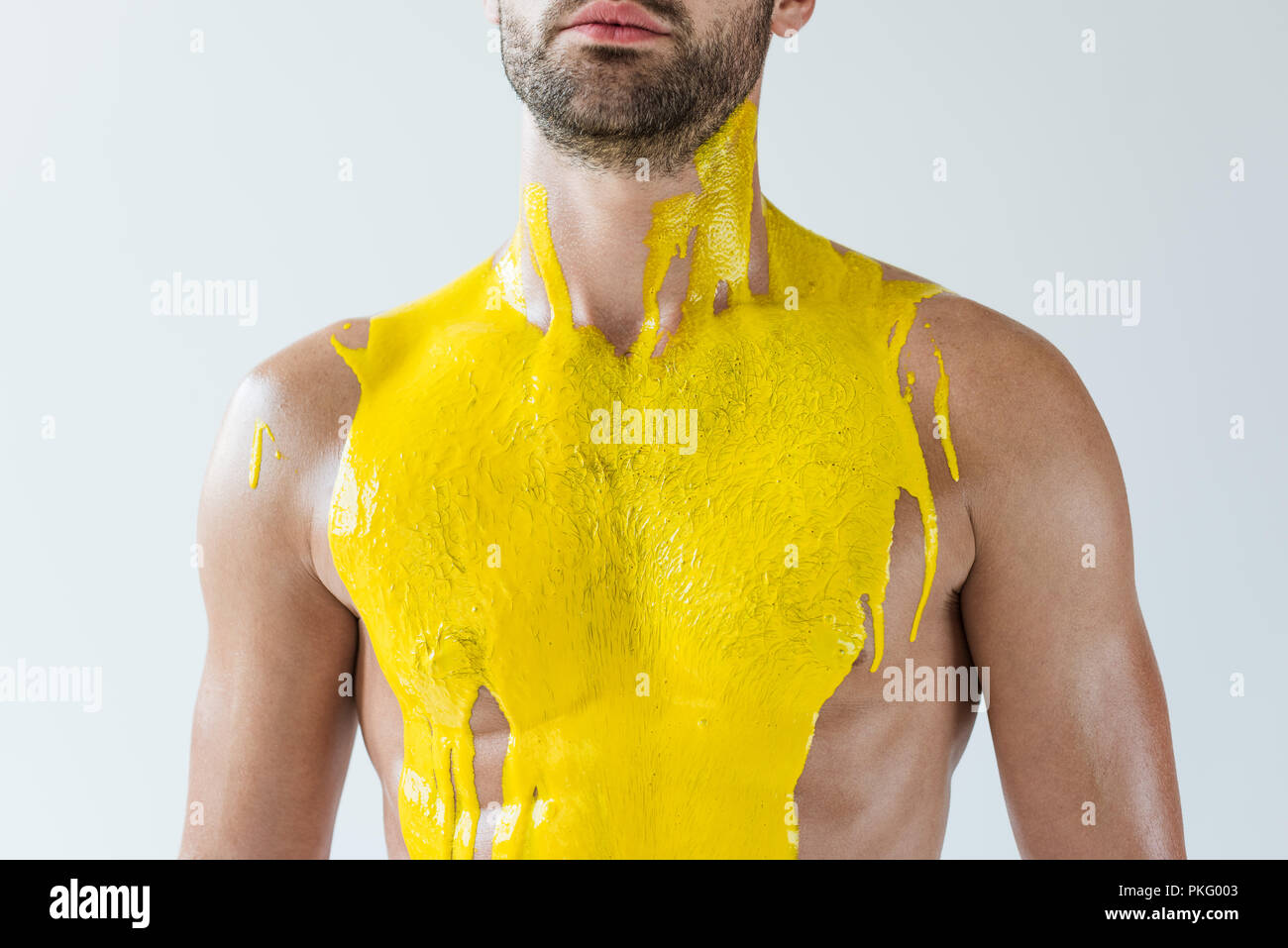 Bearded man covered with yellow paint isolated on white background ...