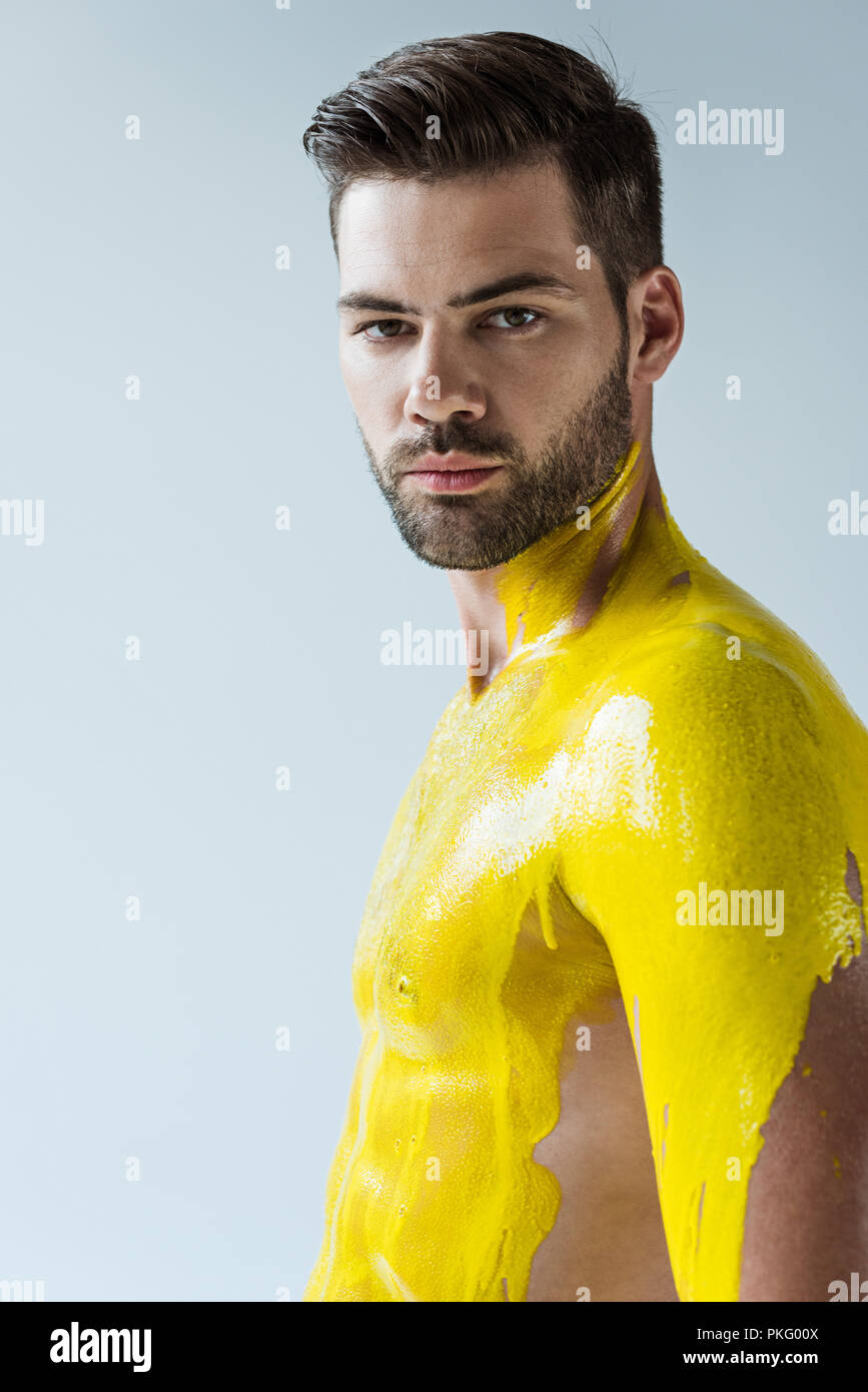 Handsome bearded man with body covered in yellow liquid isolated on ...