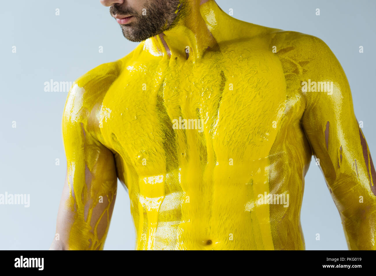 Handsome bearded man with torso covered in yellow paint isolated on ...