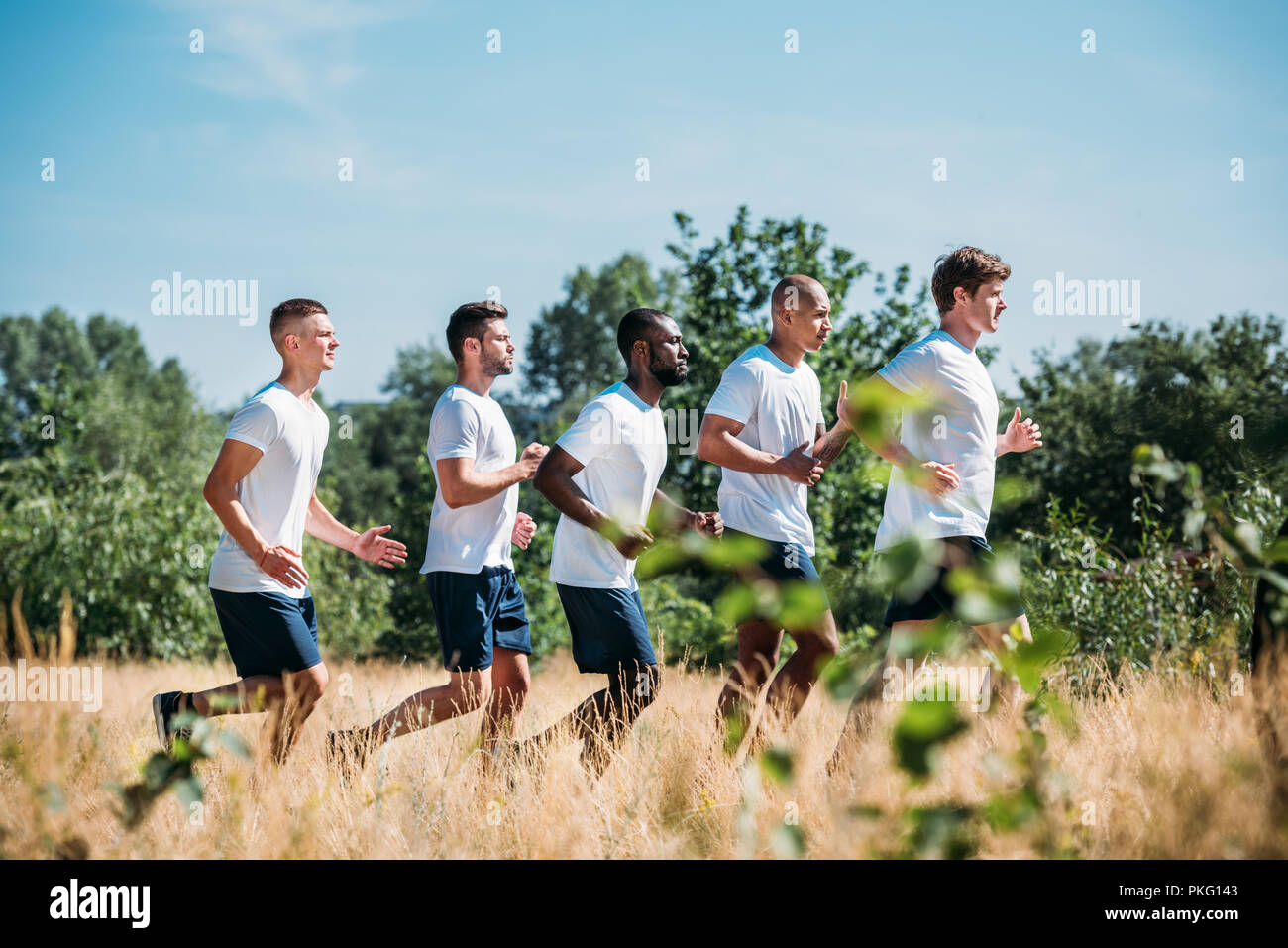 side view of multicultural group of soldiers running on range Stock ...