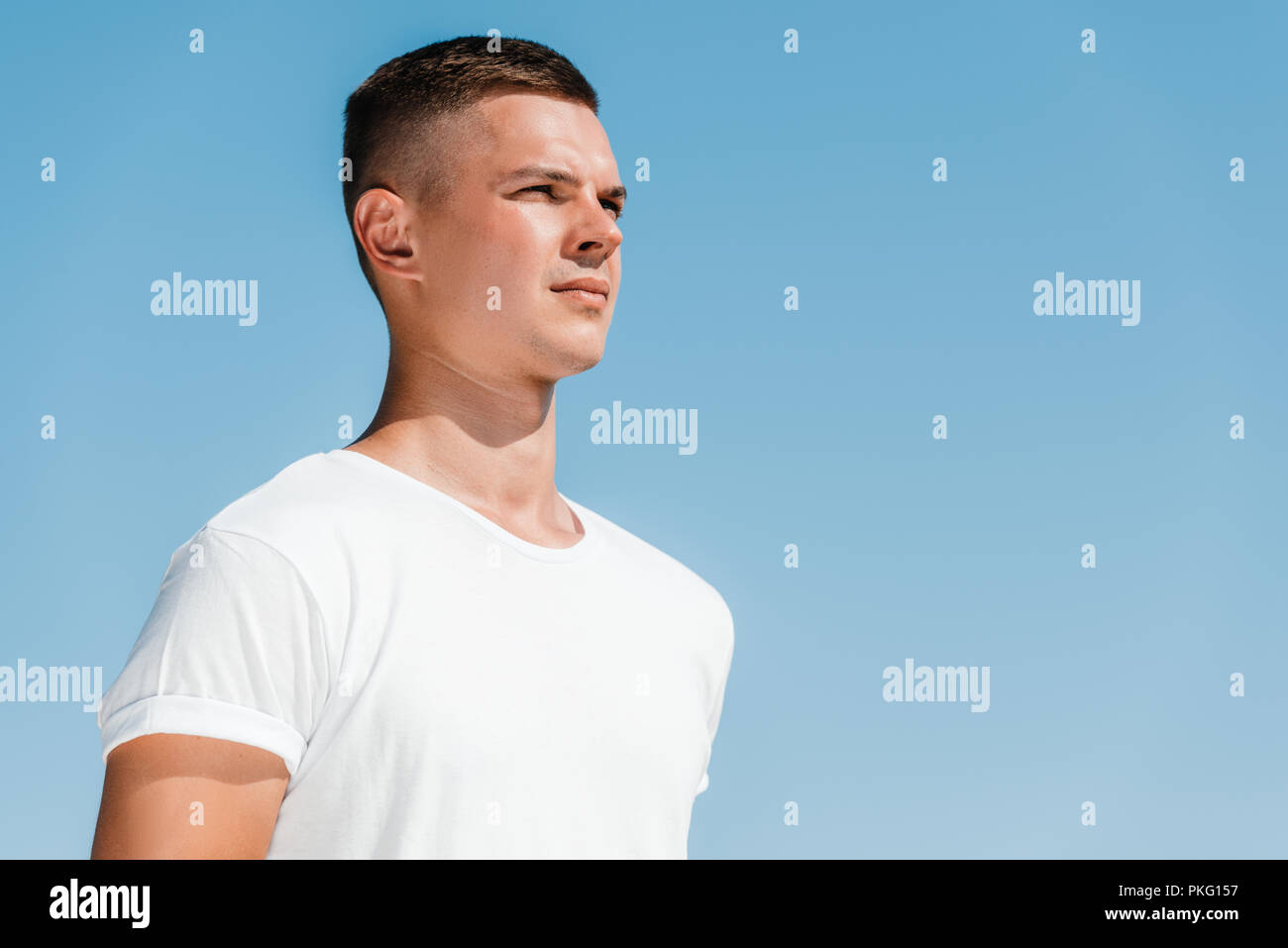 side view of young soldier in white shirt against blue sky Stock Photo ...