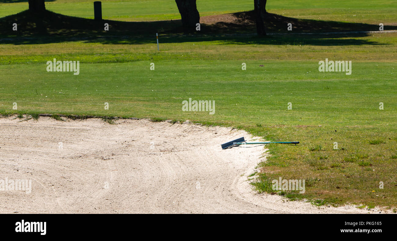 view of sand rake lying in a bunker on a golf course Stock Photo - Alamy